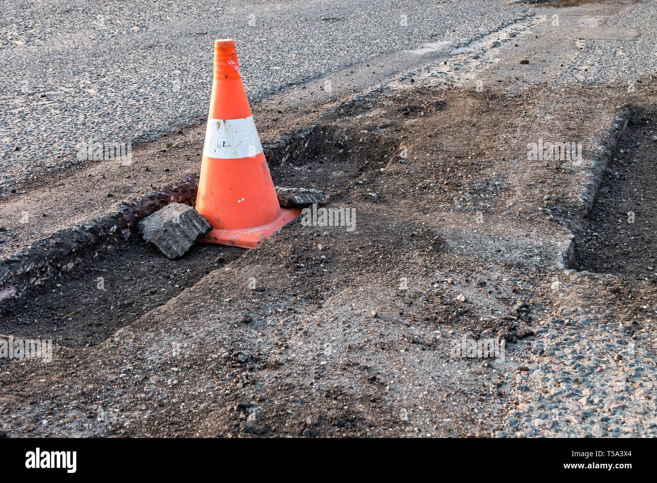 White orange traffic hazard cone on asphalt road repair Stock Photo - Alamy