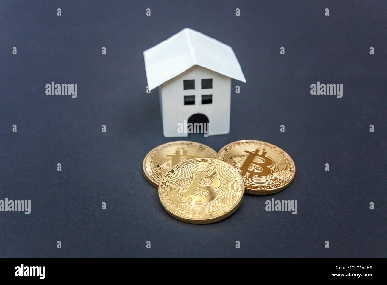 Toy house and coins bitcoin on black background. Cryptocurrency and ...