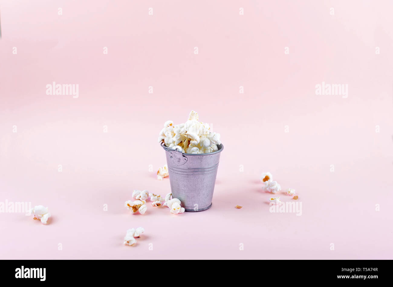 Popcorn in a bucket at the pastel pink background and a space for ...