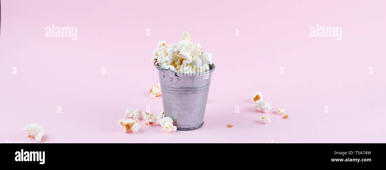 Popcorn in a bucket at the pastel pink background and a space for ...