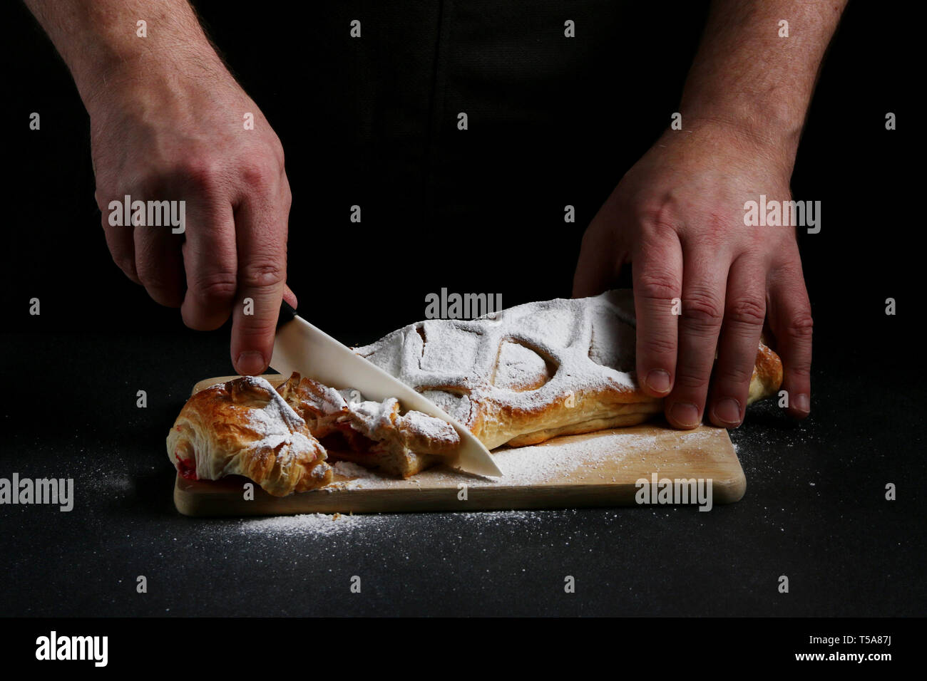 chef slices a pie on dark background. pie making concept. recipe of pie ...