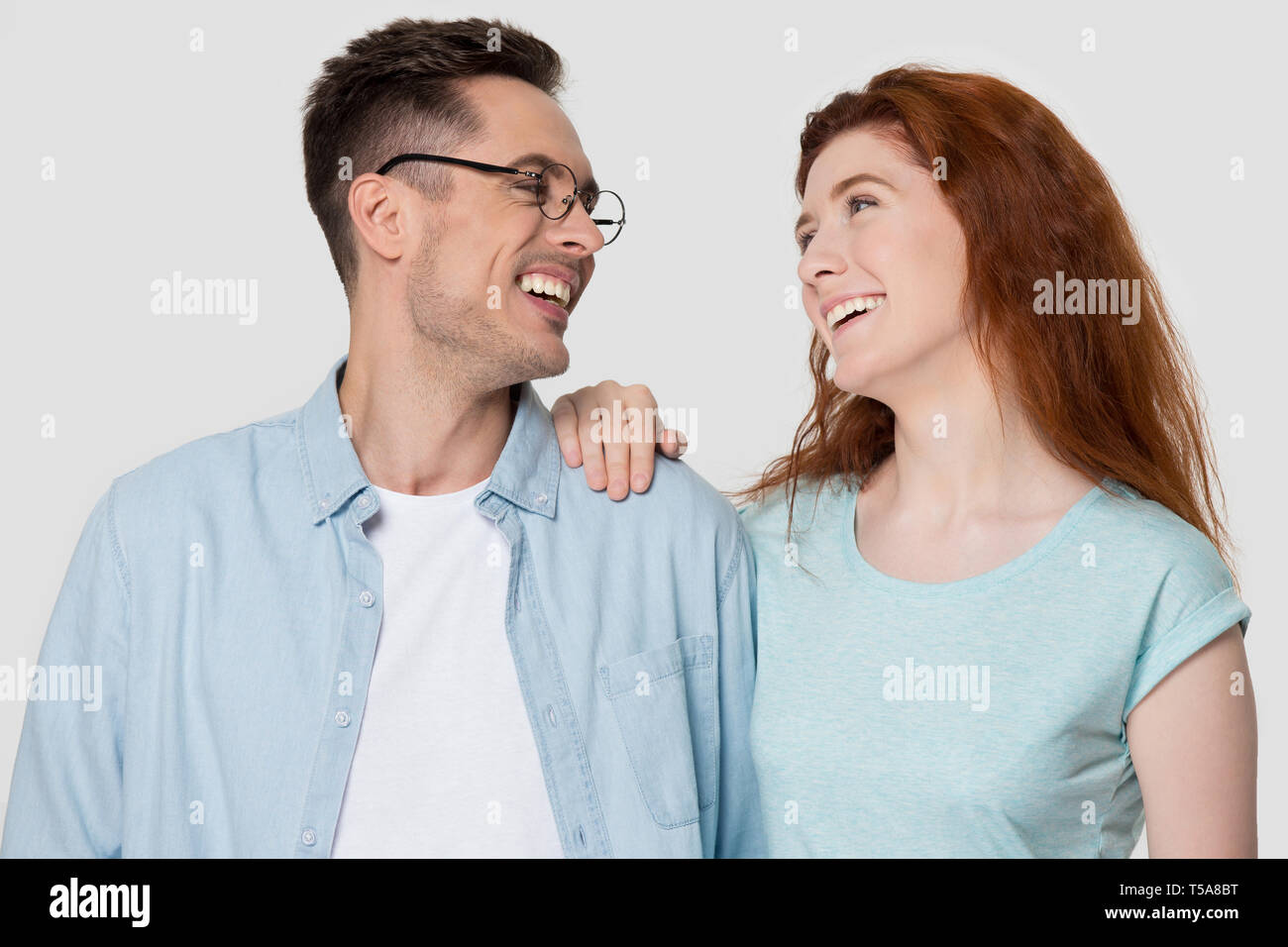 Smiling man and woman hug laughing looking in eyes Stock Photo - Alamy