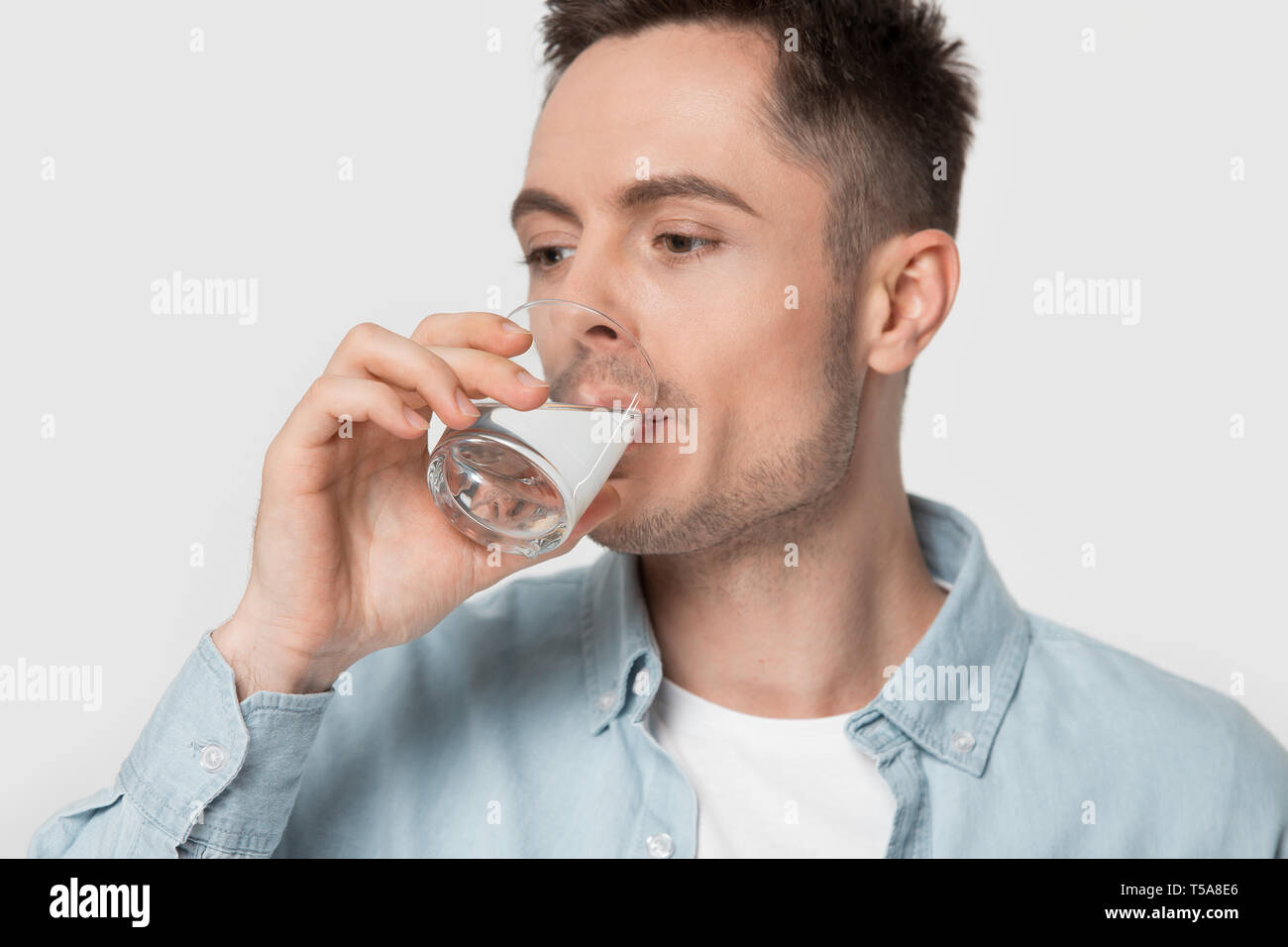 Thirsty Caucasian man drink pure mineral water from glass Stock Photo ...