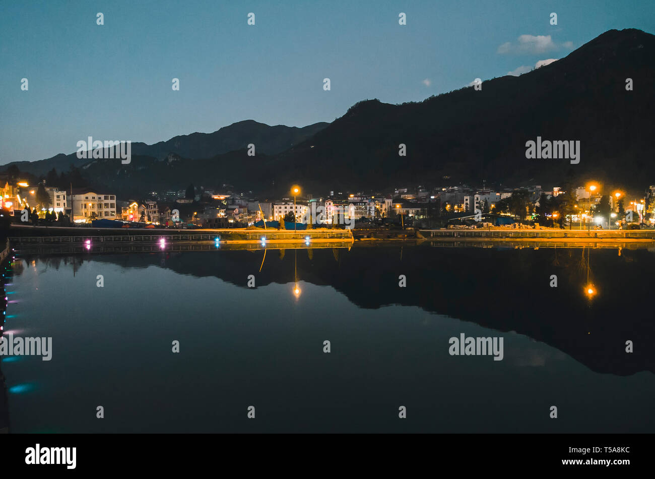 Night city landscape view with mountain background and cloudy sky ...