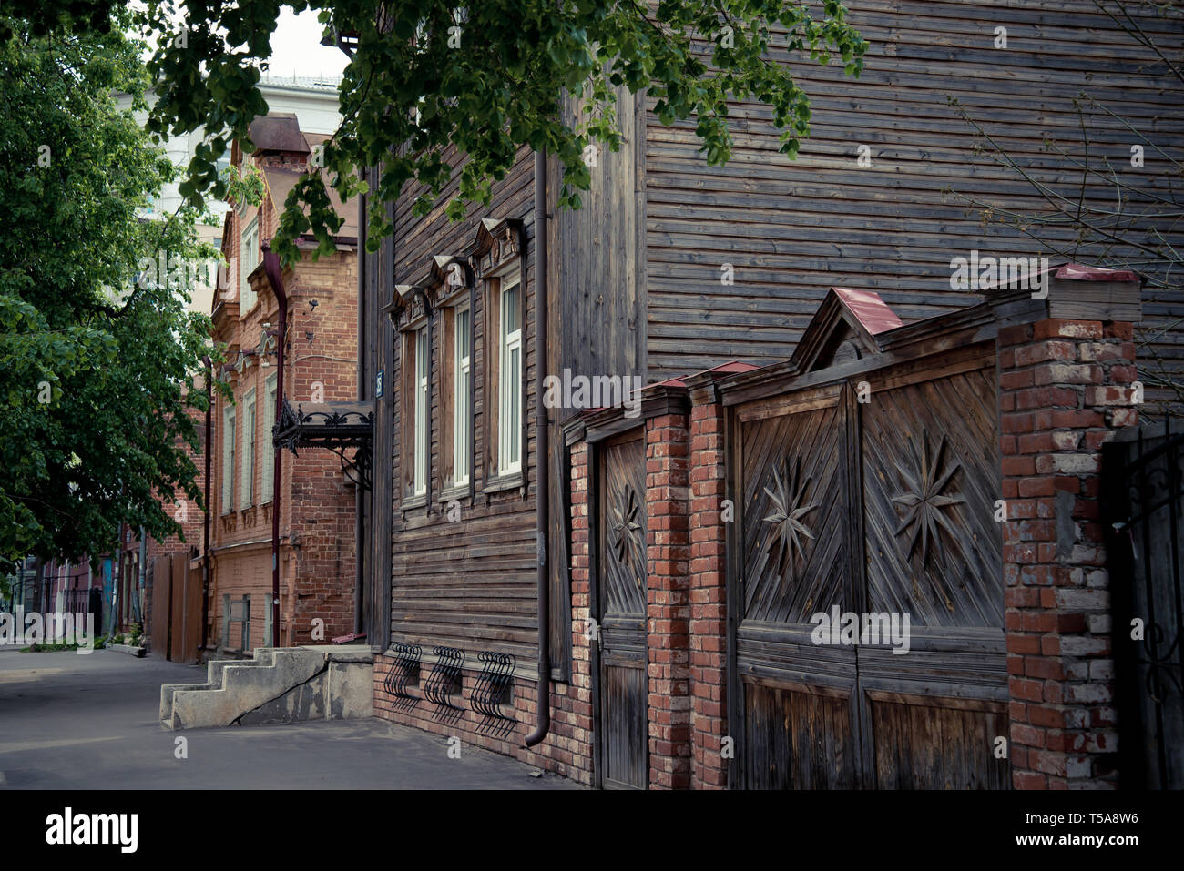 The beautiful old street with old wooden and brick houses with a porch ...