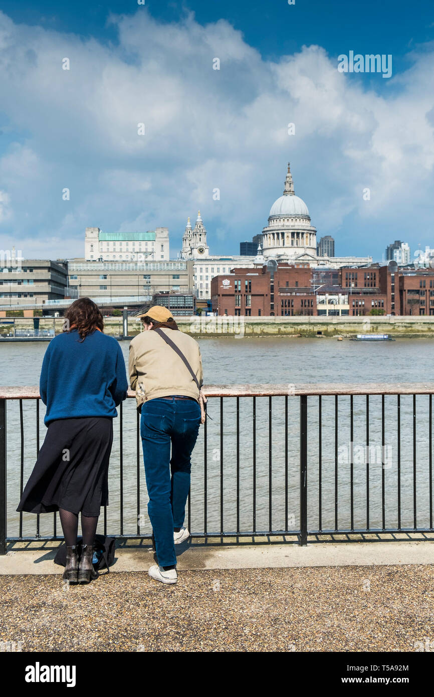 People leaning on railings overlooking the River Thames on the South ...