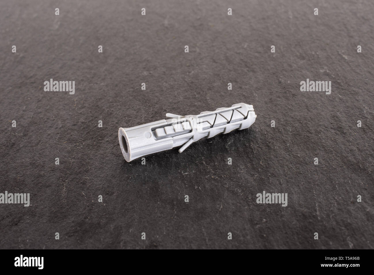 One whole plastic light grey wall plug work item on grey stone Stock ...