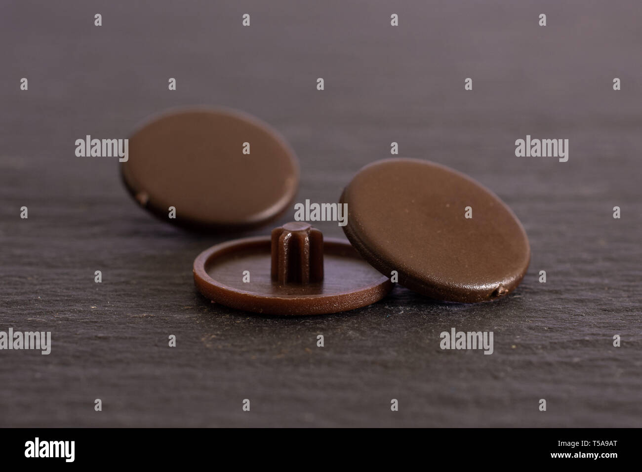 Group of three whole brown plast plugs work item on grey stone Stock ...