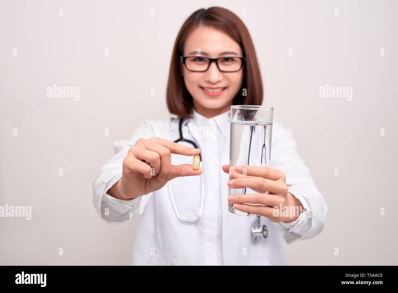 Doctor woman holding water and medicine on white background Stock Photo ...