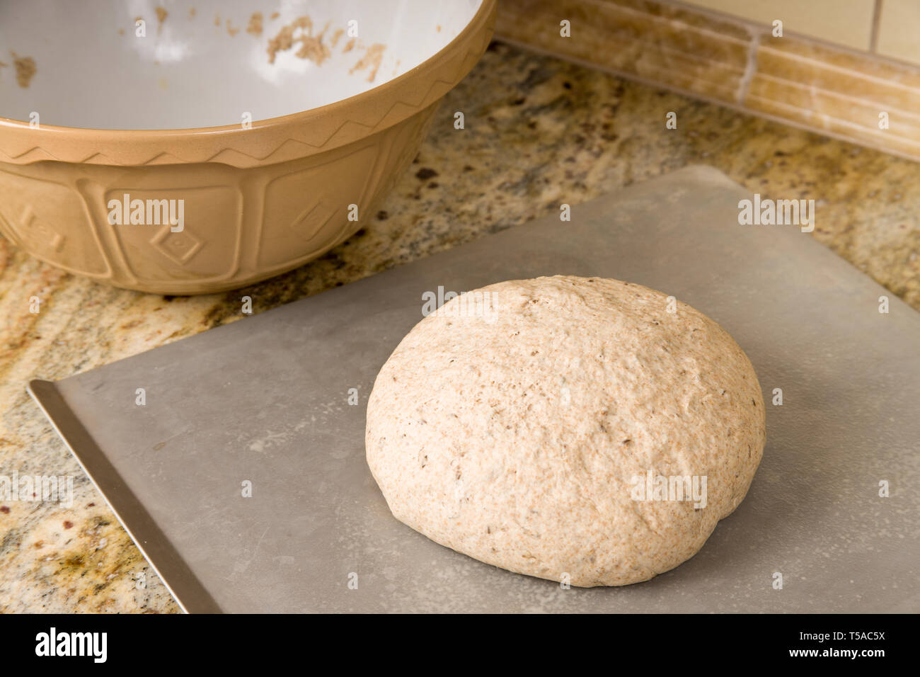 Sourdough rye bread that has been formed into a round loaf and is now ...