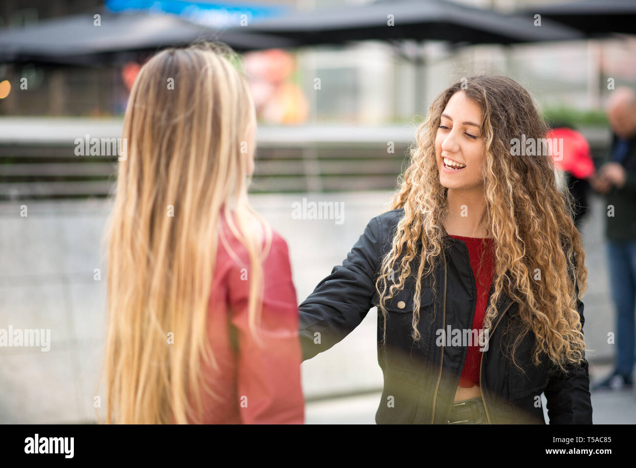 Female friends meeting in a city Stock Photo - Alamy