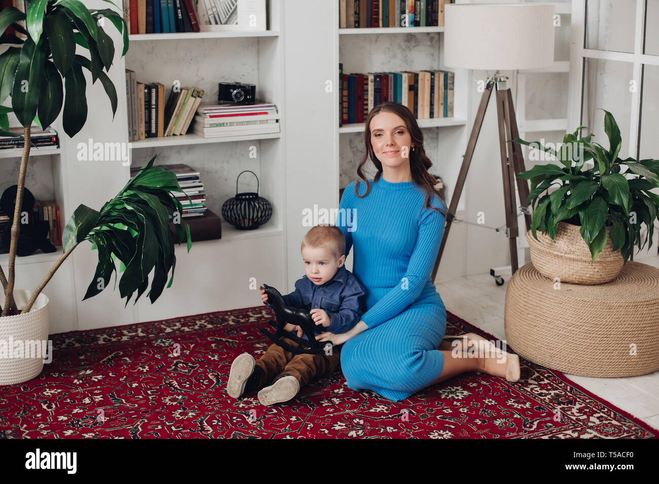 Gorgeous loving mum in blue dress with her son in living room Stock ...