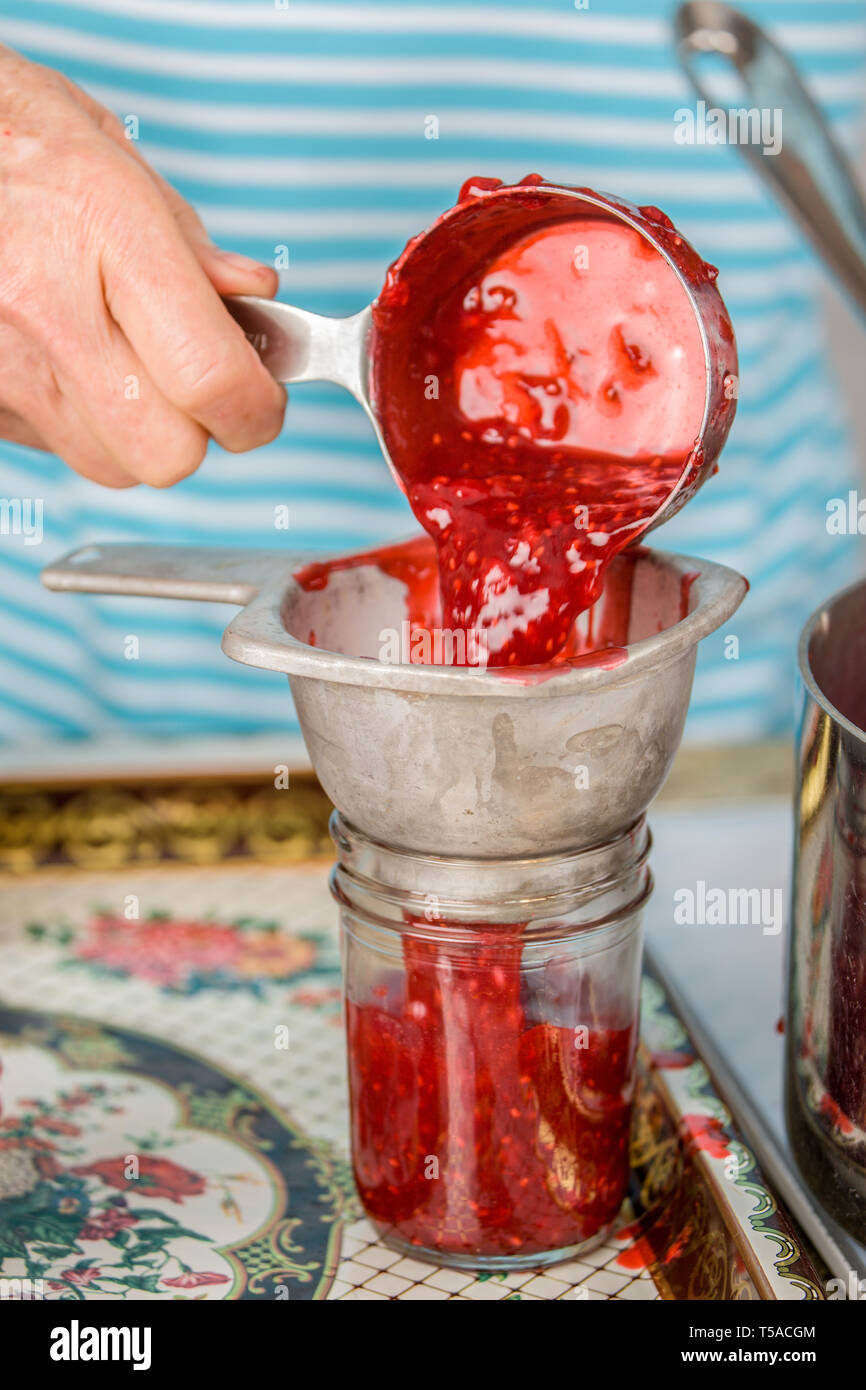 Woman filling jars with raspberry jam. Fill your awaiting (sanitized ...