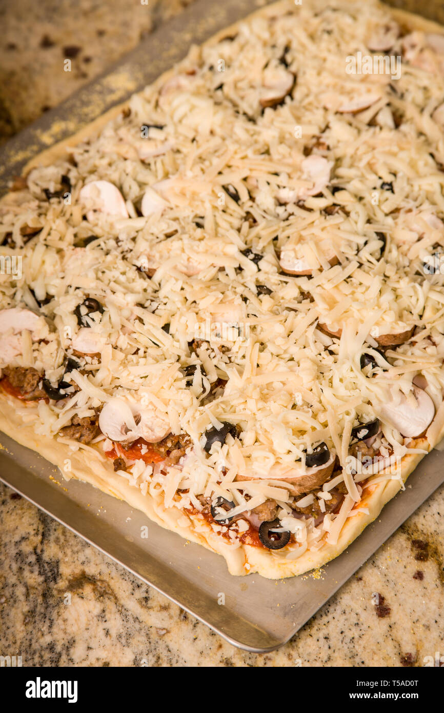 Unbaked homemade meat and veggie pizza with toppings of sausage ...