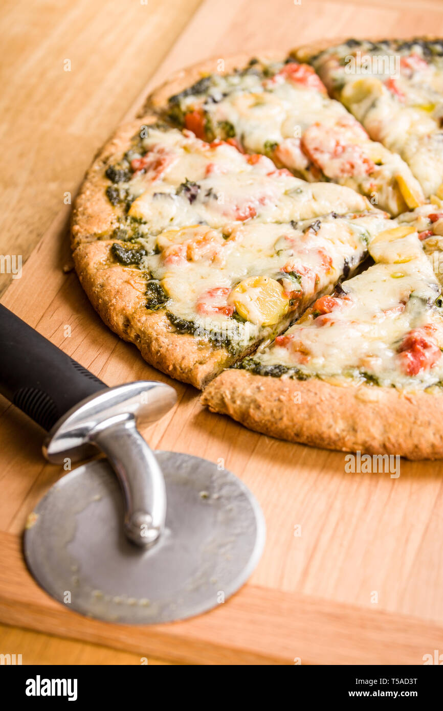 Pizza cutter and a freshly-baked, vegetarian, pesto, multi-grain, thick ...