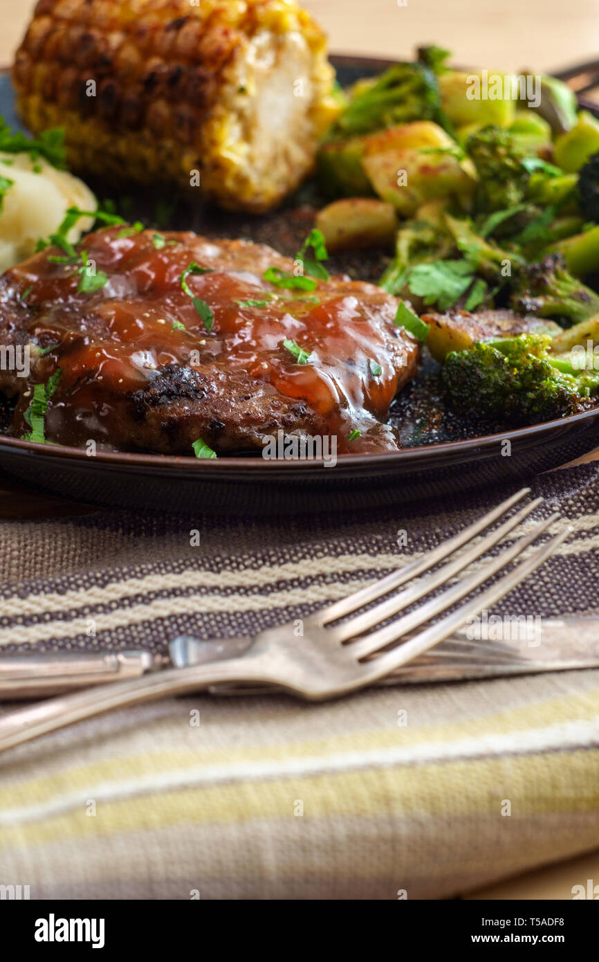 Salisbury steak with gravy served with mashed potatoes and grilled ...