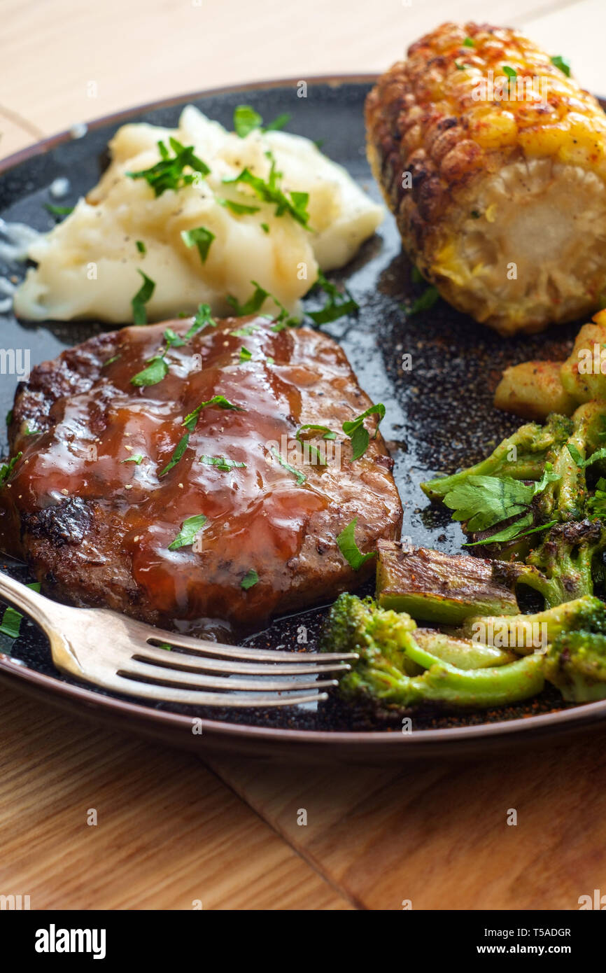 Salisbury steak with gravy served with mashed potatoes and grilled ...