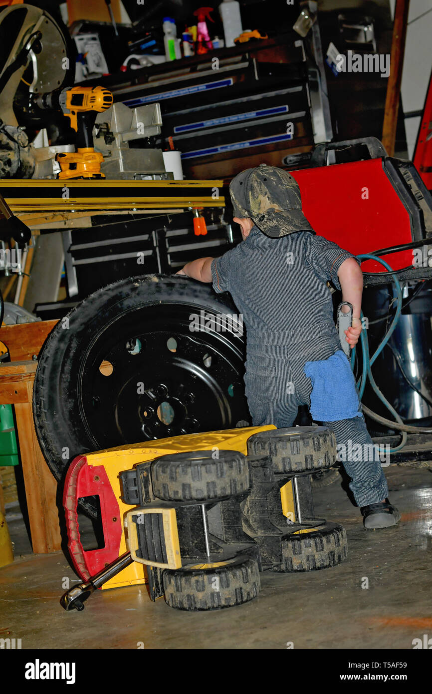 Little boy dressed as a mechanic working in a garage Stock Photo - Alamy
