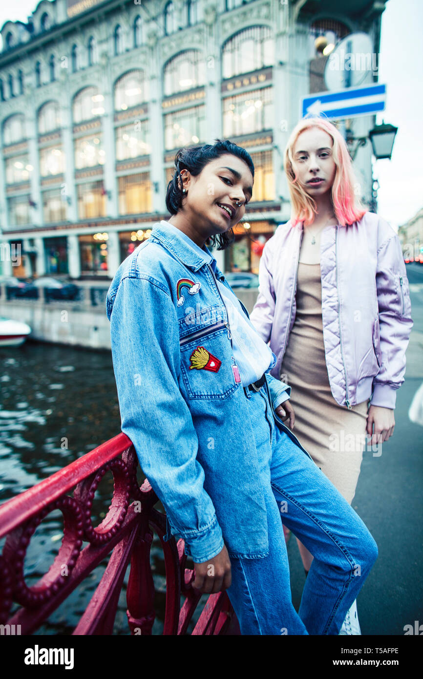 Two teenage girls infront of university building smiling, having fun ...