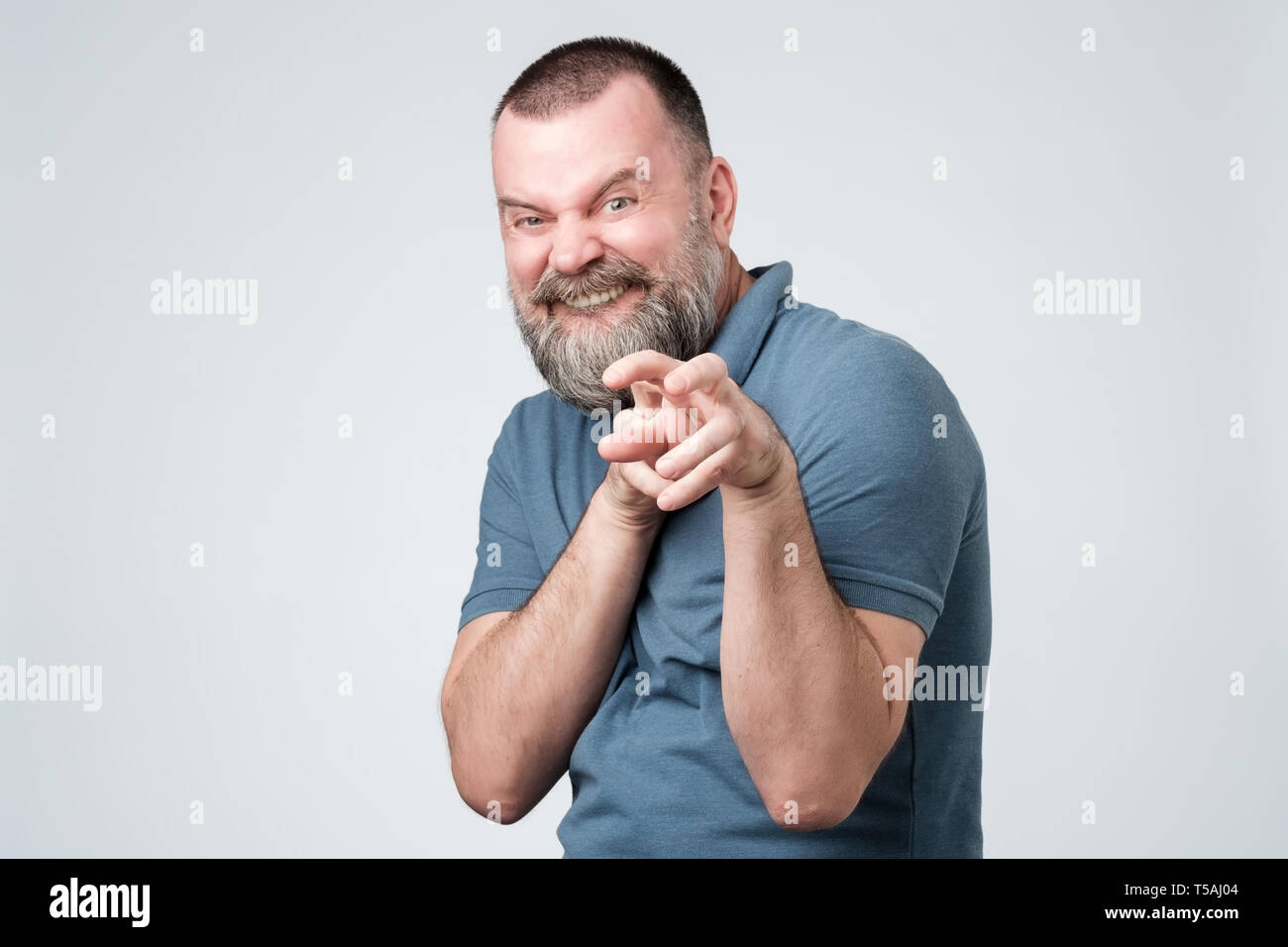 Ferocious may guy pulls his hands and shows his teeth, posing like a ...