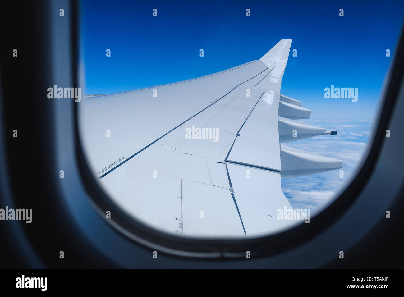 Airplane wing through passenger's window on flight Stock Photo - Alamy
