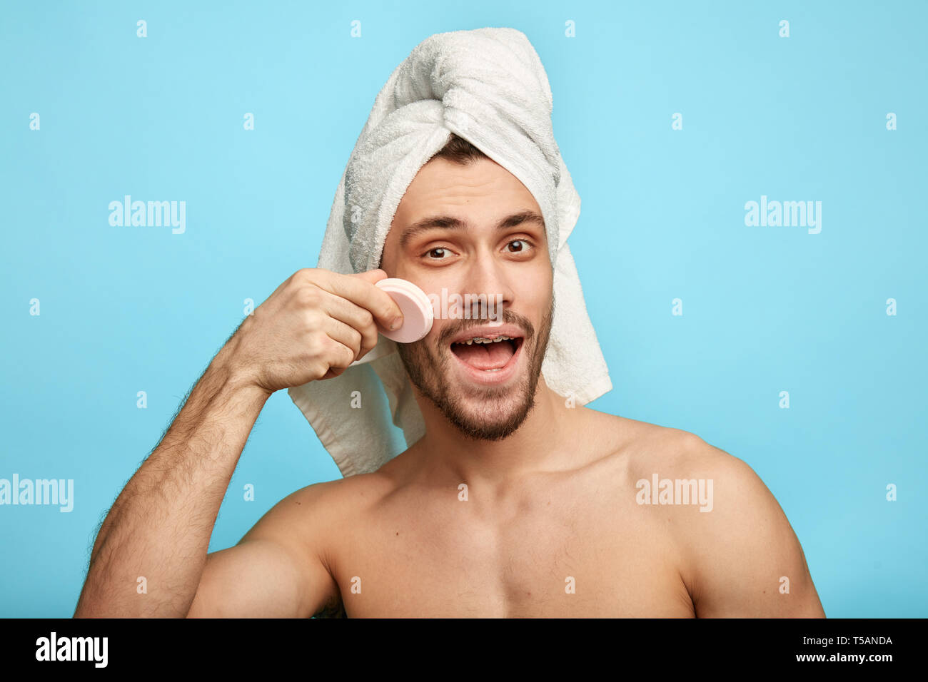 positive happy man applying powder on his face. close up portrait Stock ...