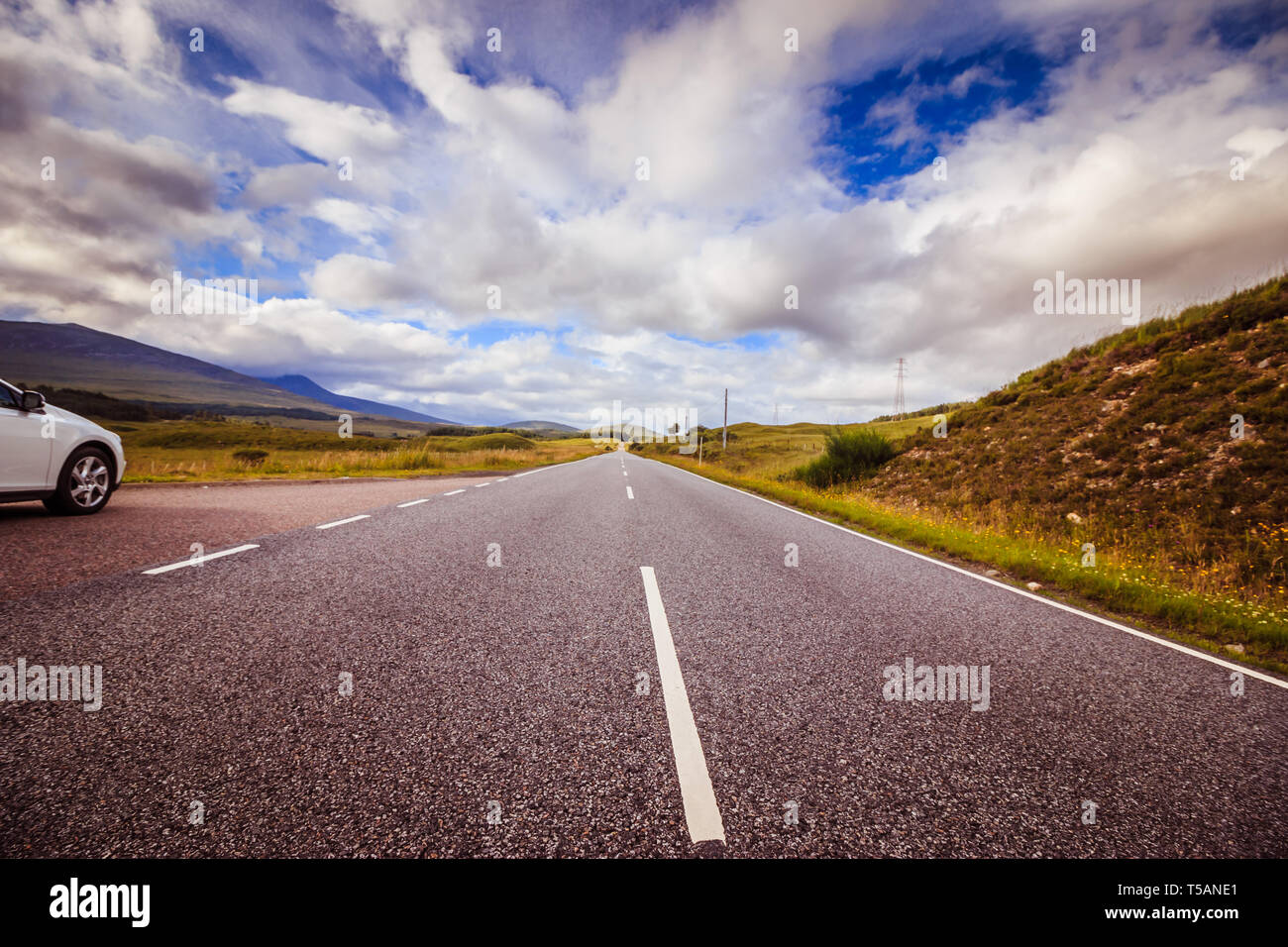 Asphalted, dramatic road in Scotland. Nobody and cloudy sky Stock Photo ...