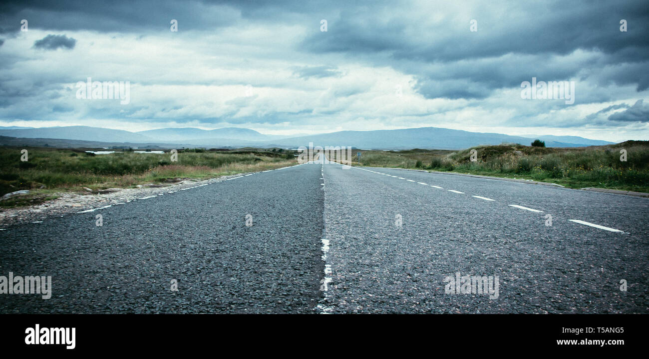 Asphalted, dramatic road in Scotland. Nobody and cloudy sky Stock Photo ...
