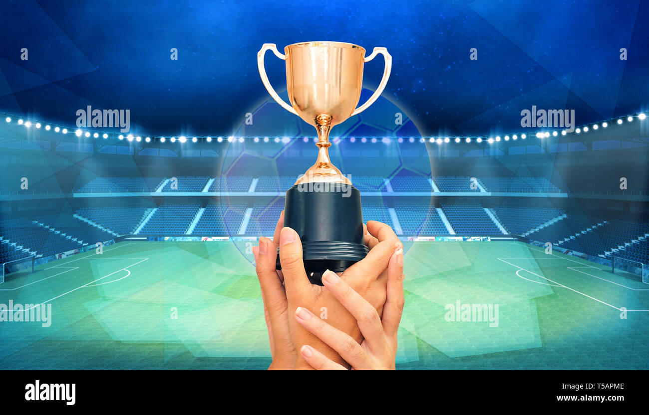 Hands hold up trophy with background football stadium Stock Photo - Alamy