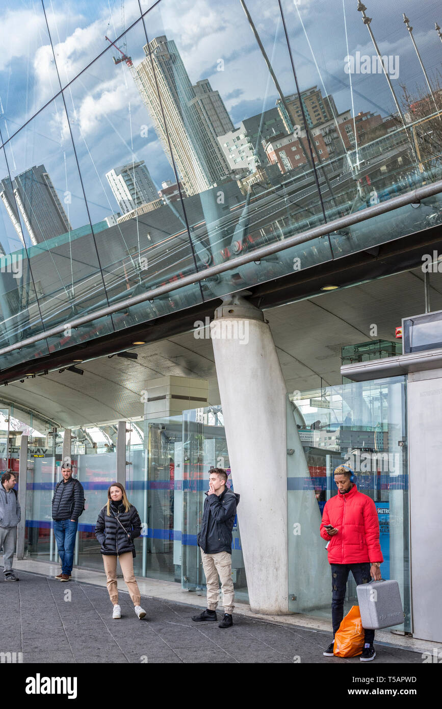 People waiting outside a station Stock Photo - Alamy