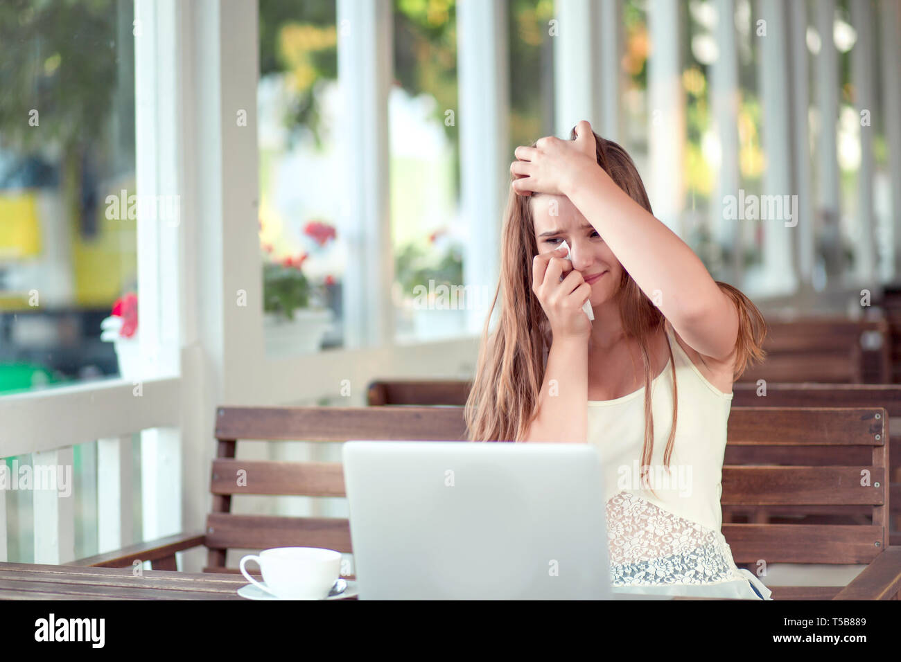 Sad woman in front of computer crying having a video chat. Mixed race ...