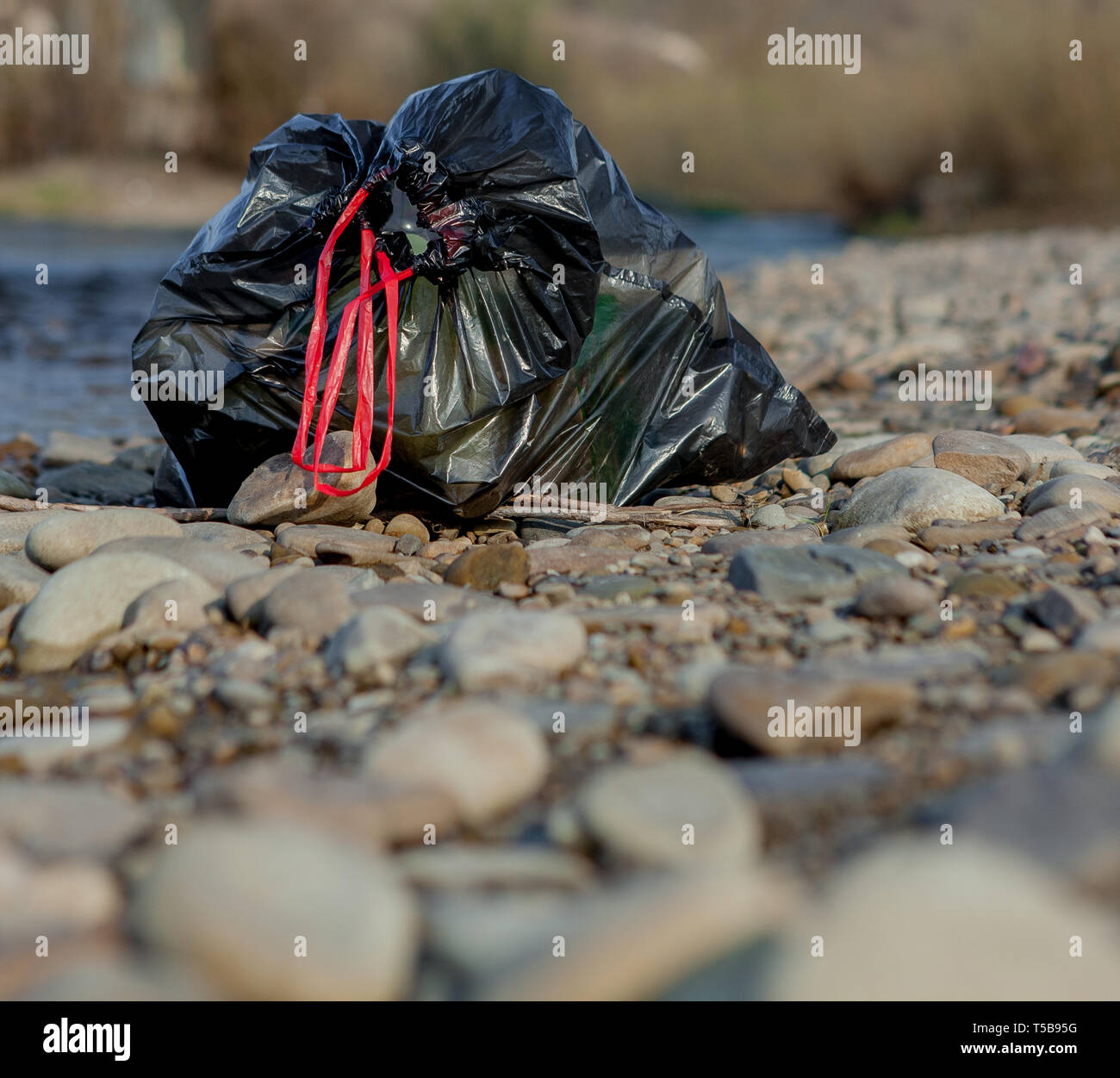 River pollution near the shore, garbage pack near the river, plastic ...