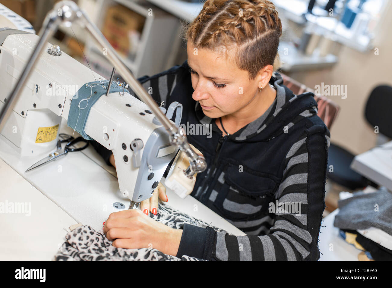 Seamstress sewing at machine, portrait. Female tailor stitching ...