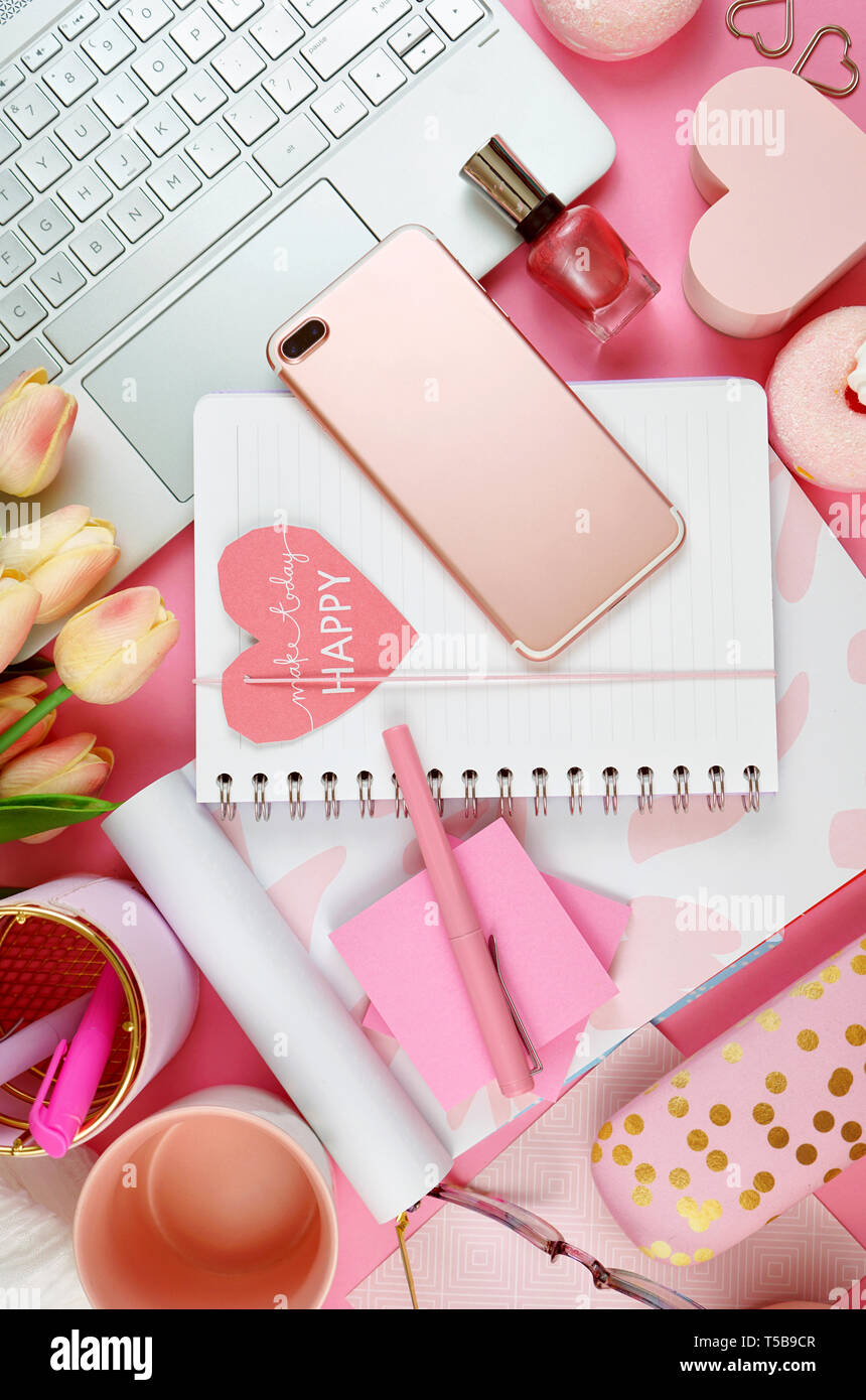 Ultra feminine cluttered pink desk workspace with touch screen laptop ...