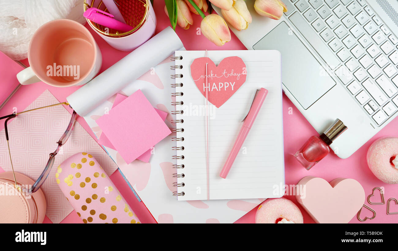 Ultra feminine cluttered pink desk workspace with touch screen laptop ...
