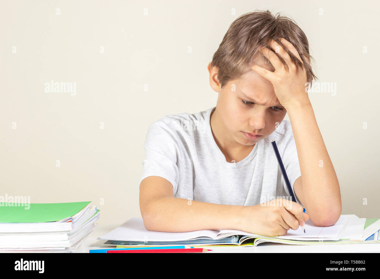 Sad boy doing homework. Education, school, learning difficulties ...