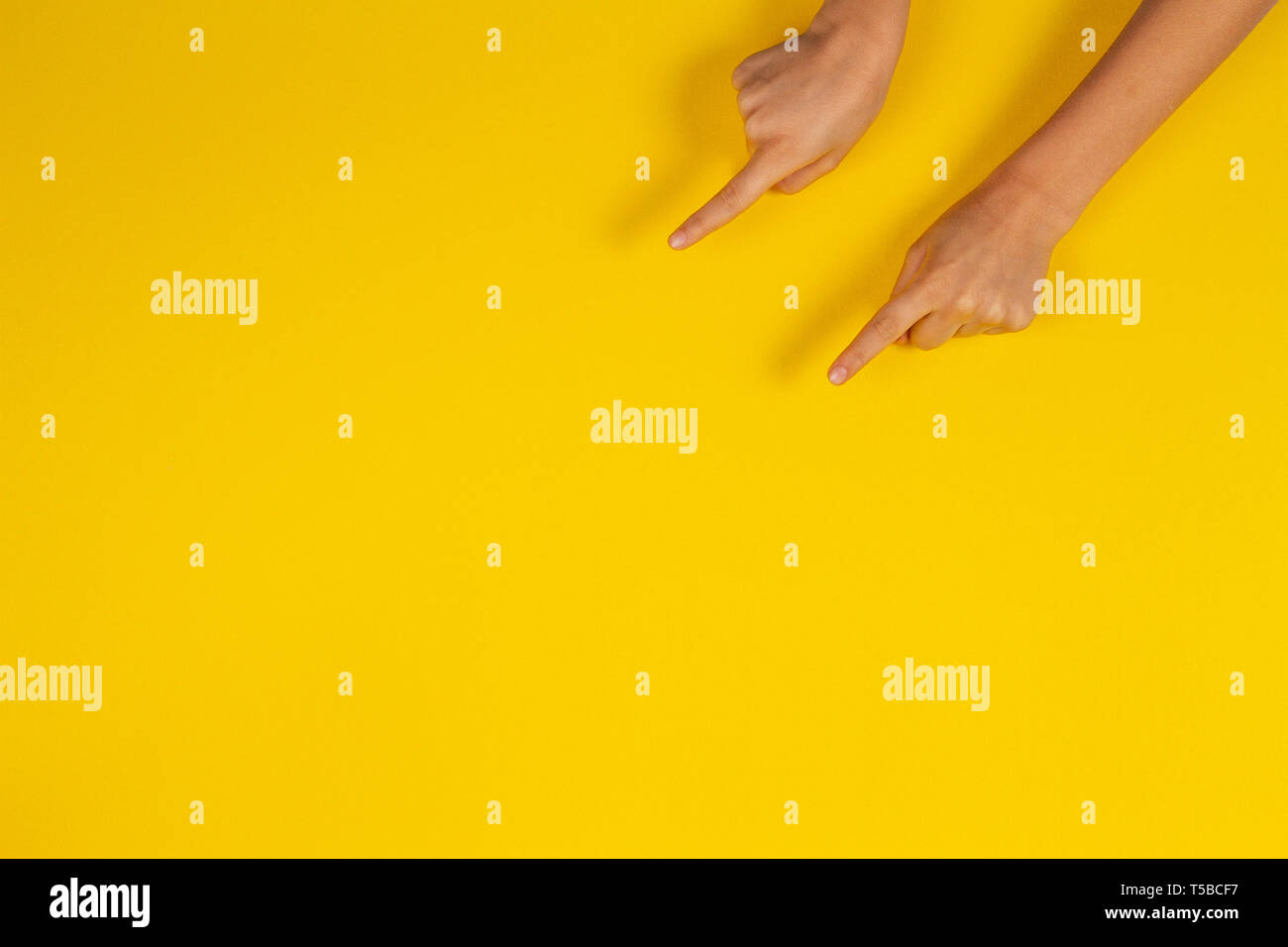 Child hands fingers pointing on yellow background Stock Photo - Alamy