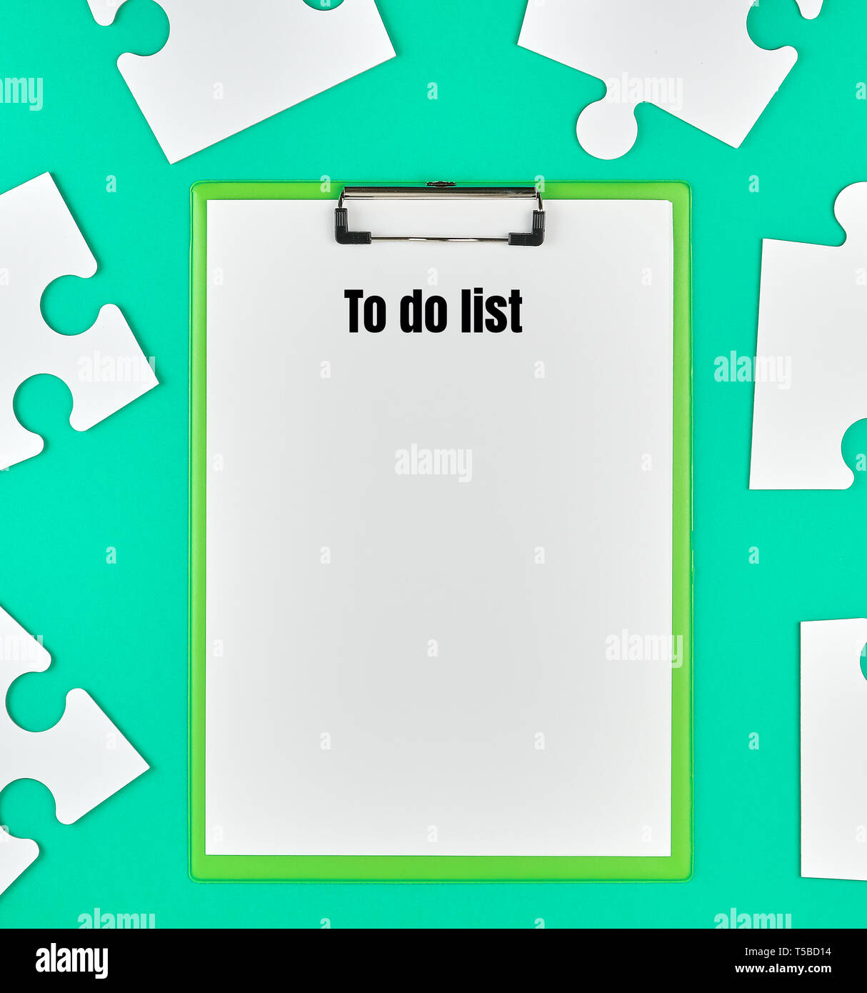 paper clip and white large paper puzzles on a green background, top ...