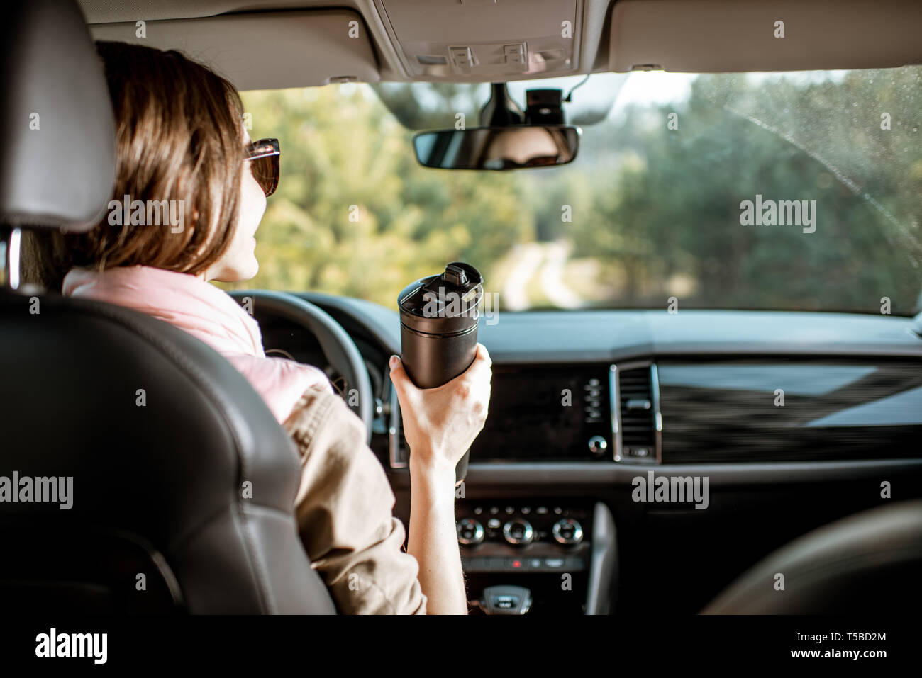 Woman driving car on the forest road, view from the car interior Stock ...