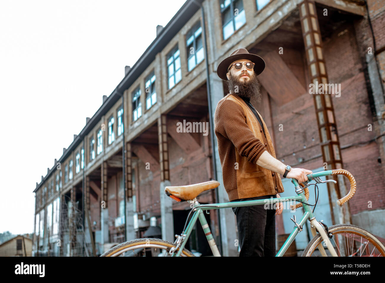Lifestyle portrait of a bearded hipster dressed stylishly walking with ...