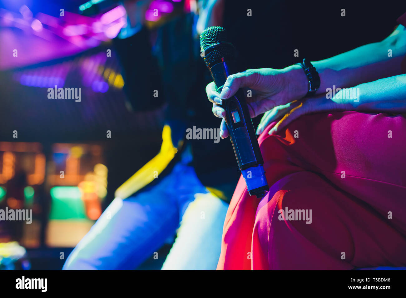 The female student is holding the black wireless microphone in the left ...