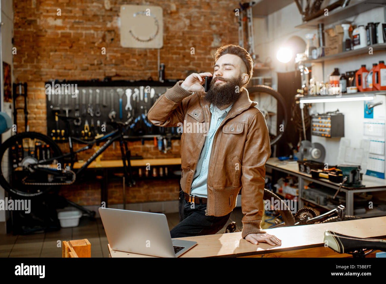 Businessman as a shop owner or manager talking with phone in the ...