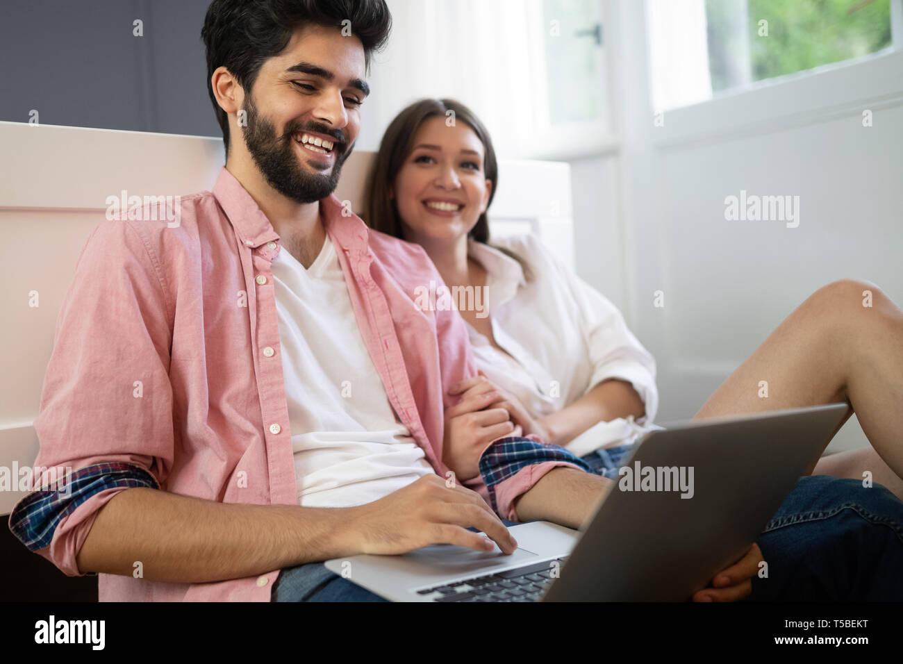 Couple looking laptop computer together hi-res stock photography and ...