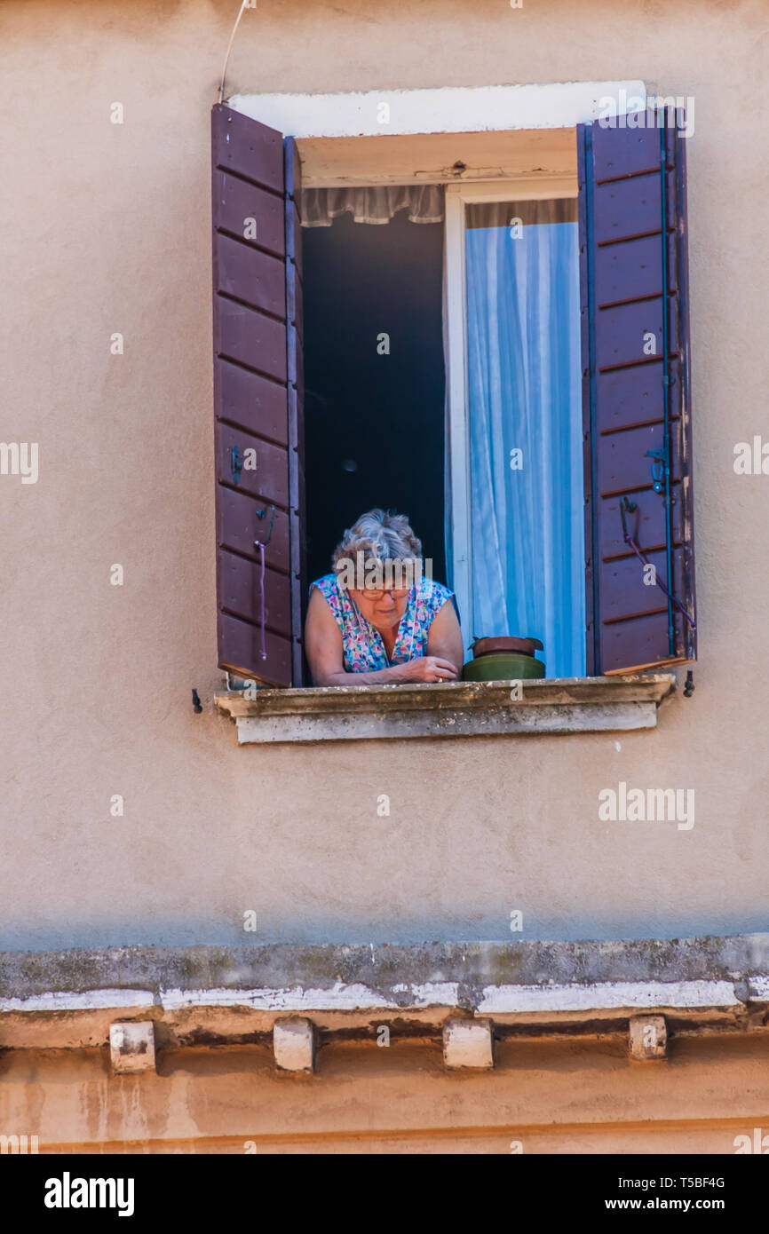 An aged woman is watching from a window, Venice Stock Photo - Alamy