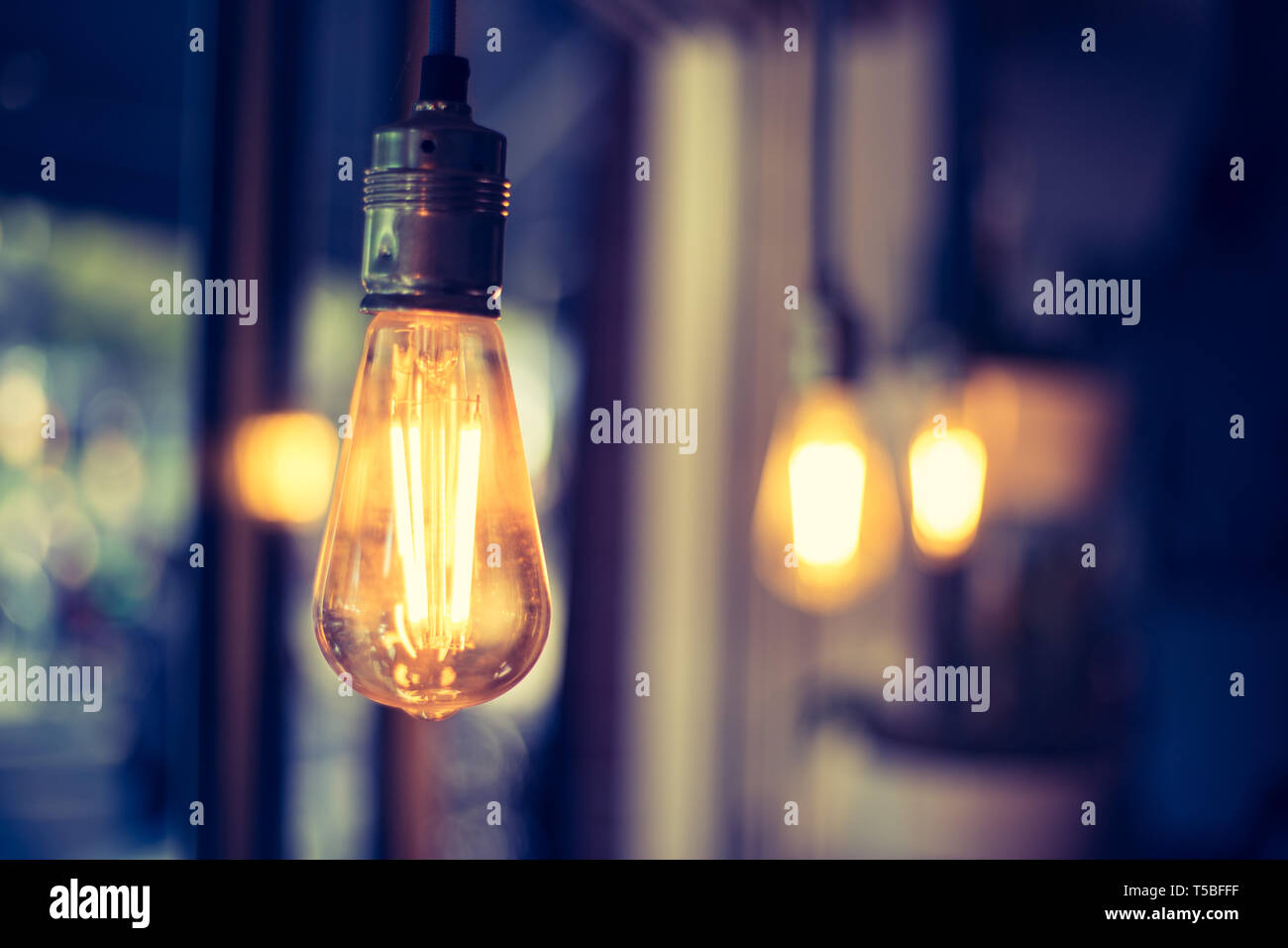 Close up picture of a hanging orange lightbulb in a restaurant or café ...