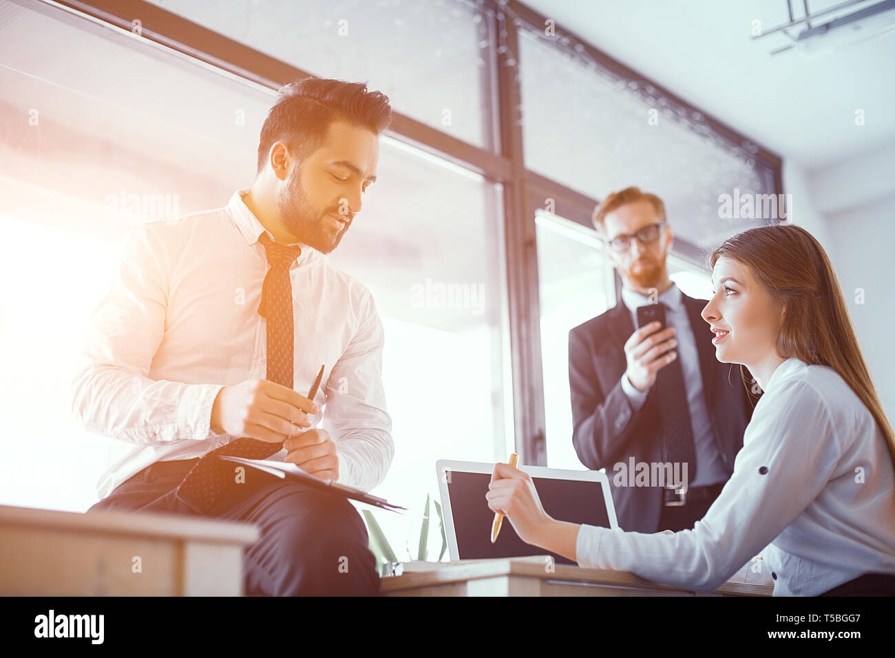 Male Colleagues Listening To Beautiful Female Partner In Sunny Office ...