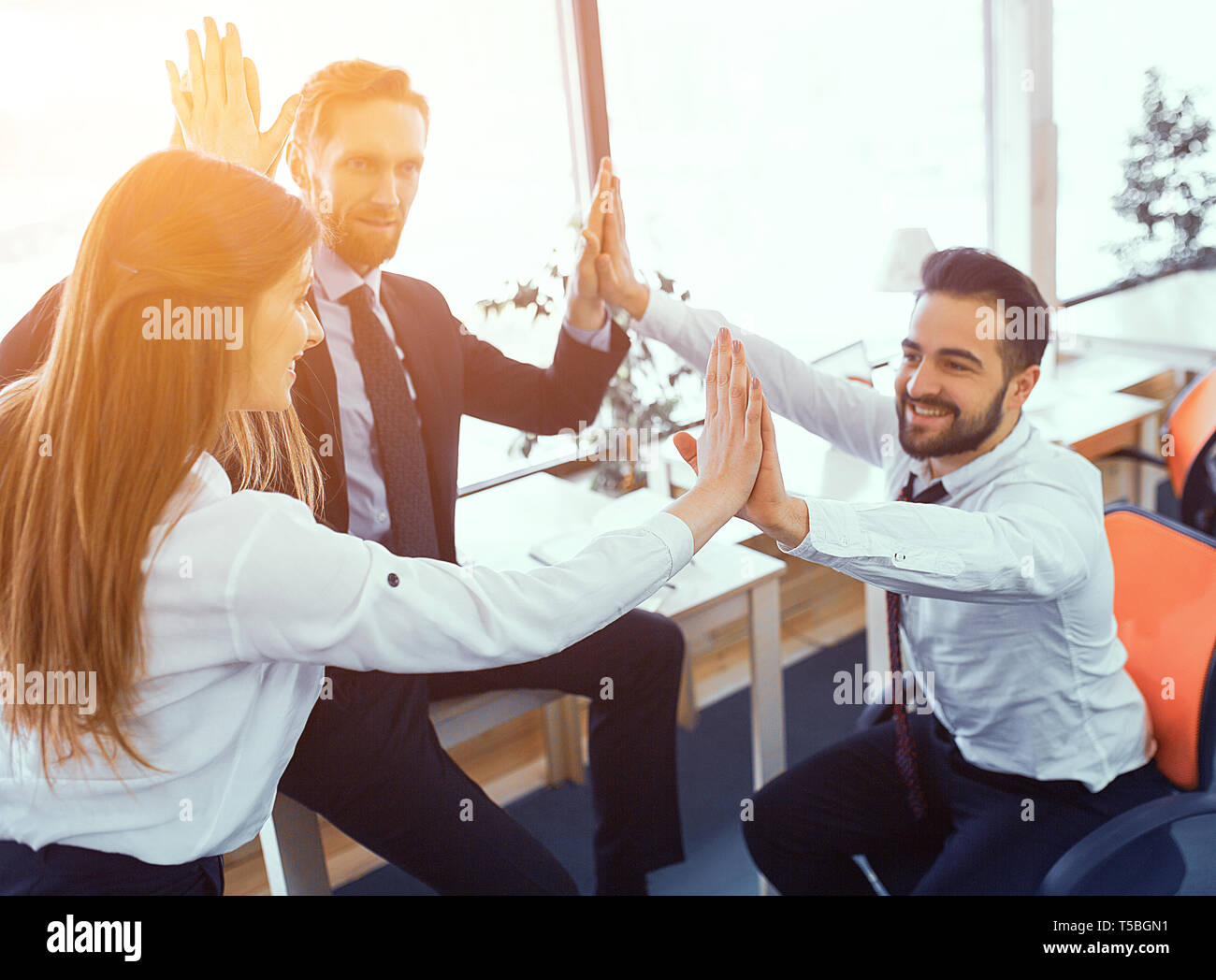 Business Colleagues Giving Five In Sunny Office After Successful ...
