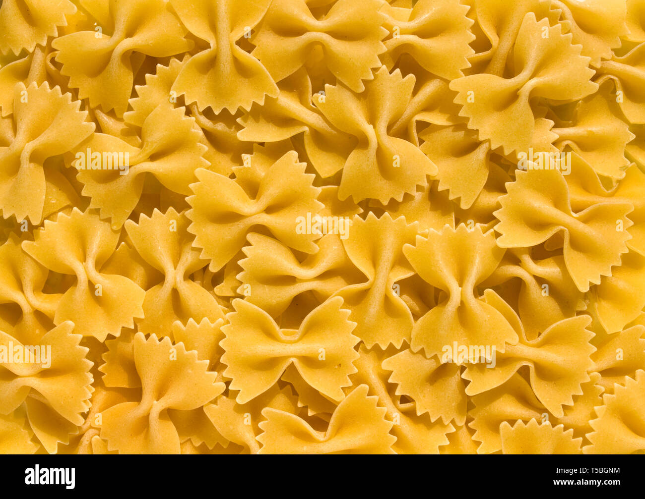 Farfalle - bow shaped pasta background Stock Photo - Alamy