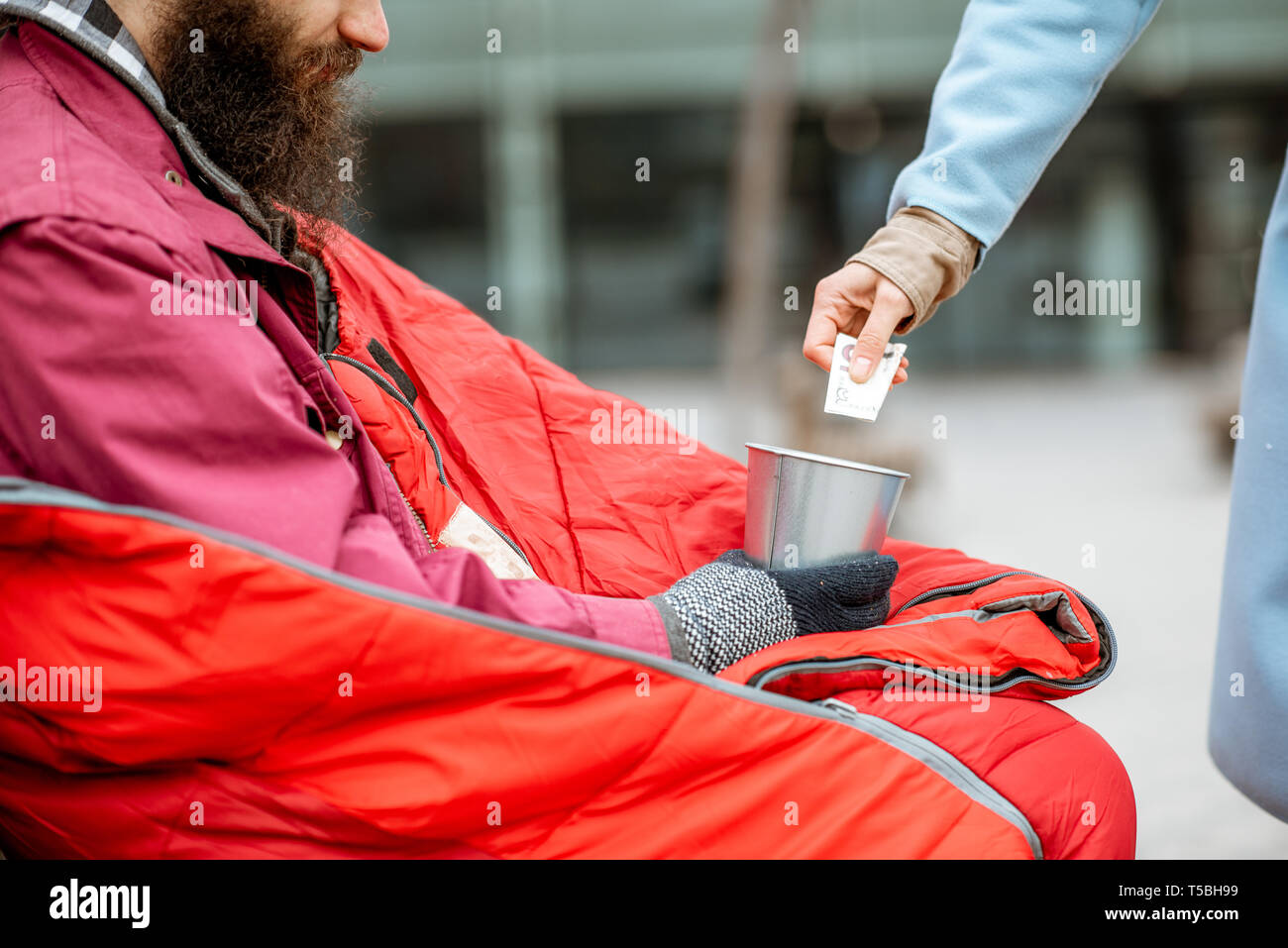 Woman giving some money for a homeless beggar, close-up view. Concept ...