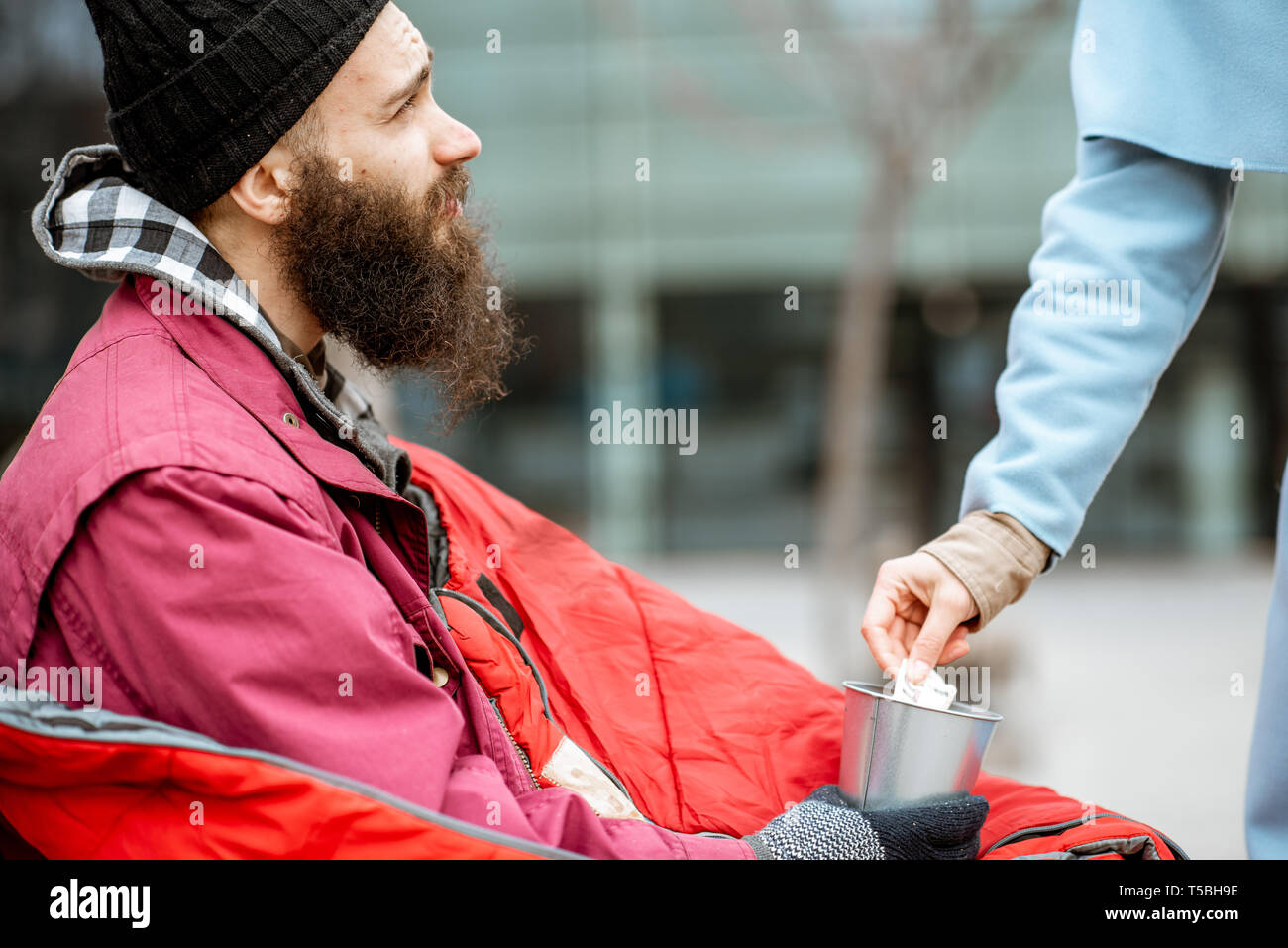 Woman giving some money for a homeless beggar, close-up view. Concept ...